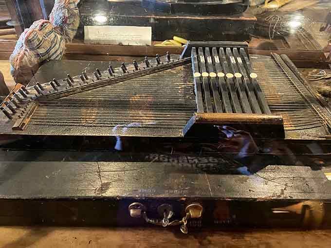 An antique autoharp sitting quietly in the corner, proof that beautiful things were made long before electricity ran the show.