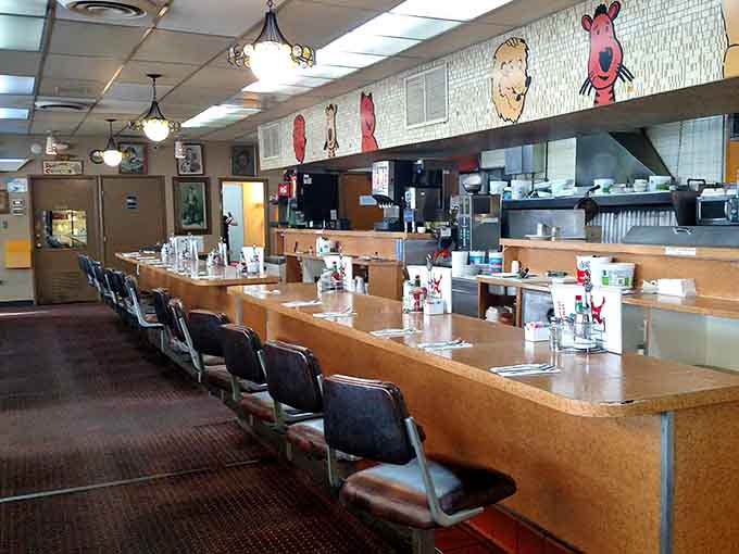 The long counter stretches out beneath cheerful circus characters, every stool quietly waiting for its next regular to arrive.