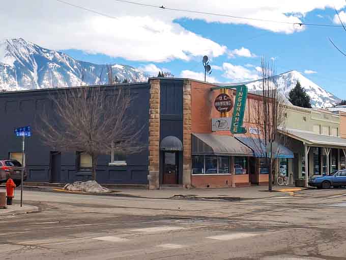 An old insurance sign, a corner building, and mountains so dramatic they look borrowed from a movie set. Just another Tuesday in Paonia.