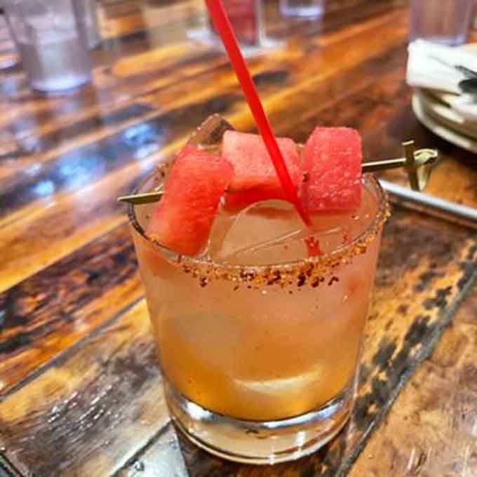 A spicy watermelon margarita with a chili-rimmed glass and fresh watermelon garnish. Refreshing, bold, and surprisingly fun.