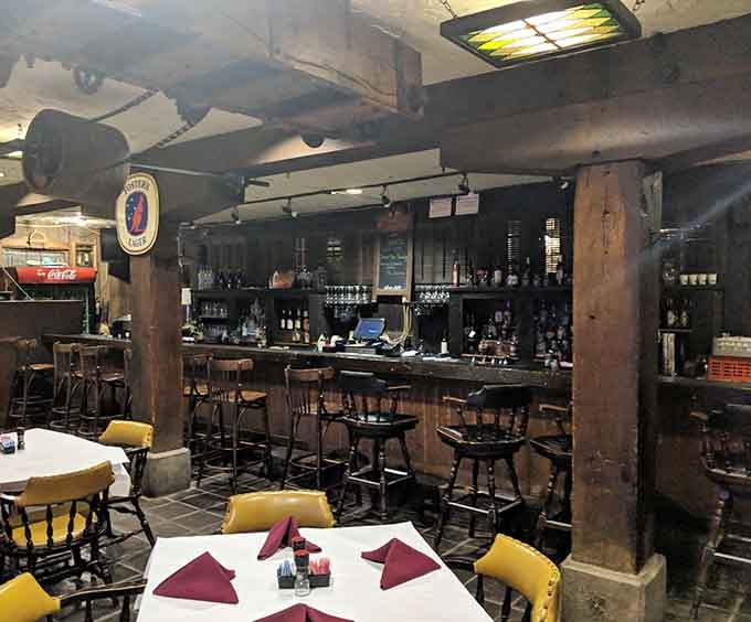 Dark wood, warm lighting, and a full bar tucked beneath those iconic beams. This is where the evening begins.