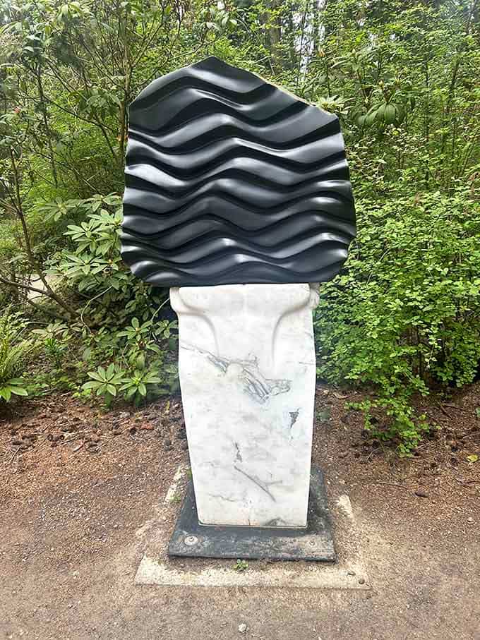 A striking black wave form sits atop white marble, looking like the Pacific Ocean decided to become a sculpture.
