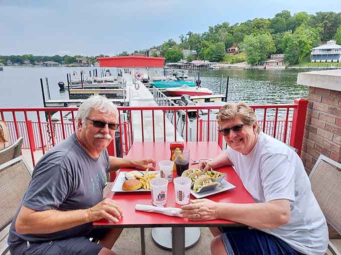 Good food, great company, and boats in the background, these two have clearly figured out the perfect afternoon.