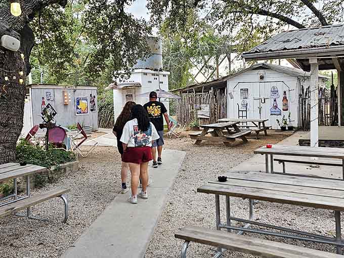 Gravel paths, picnic benches, and shade trees overhead. Riley's outdoor space is a Texas afternoon done right.