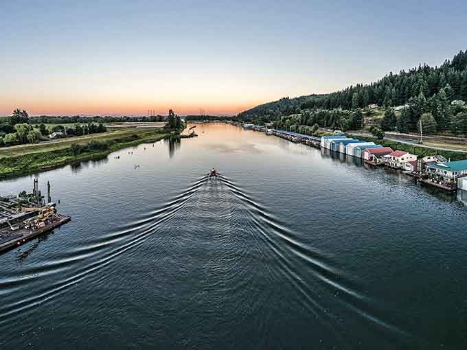 A lone boat cuts through the Multnomah Channel at golden hour, leaving a perfect wake behind like punctuation on a great day.