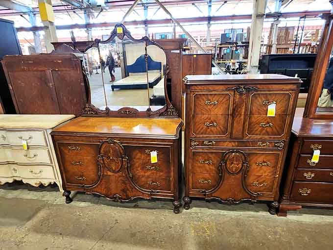 That burled walnut dresser set with the carved mirror is the kind of furniture that makes people stop mid-sentence and stare.
