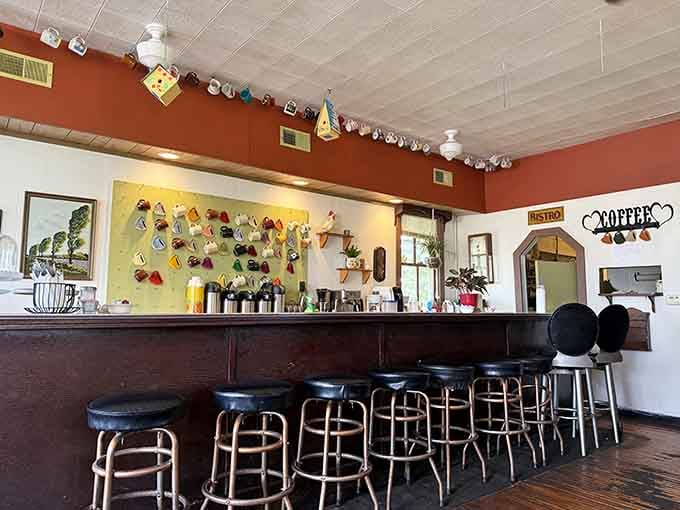 A whole wall of colorful mugs and a long counter with barstools. This is where good mornings actually happen.