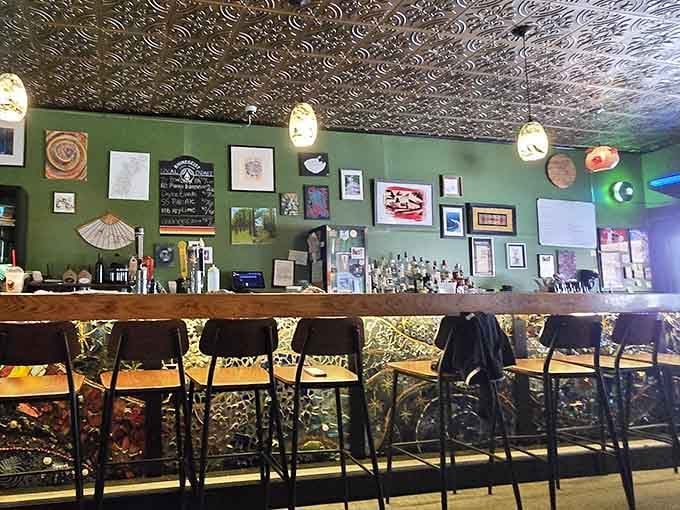 A bar lined with local artwork and warm pendant lights, built for lingering over a second drink.