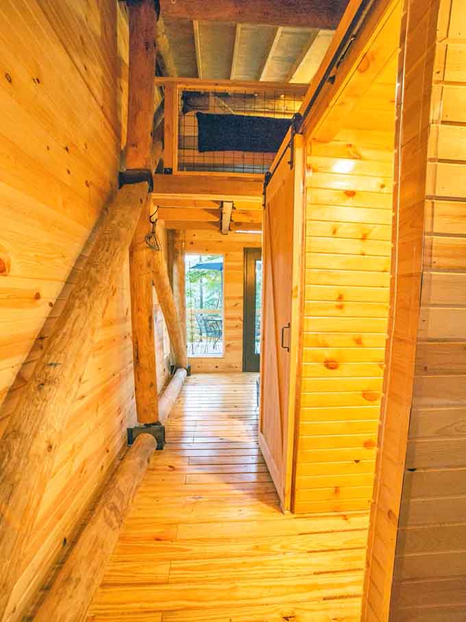 Sunlight at the end of the hallway, framed by wood and a sliding barn door. Pure Alabama charm.