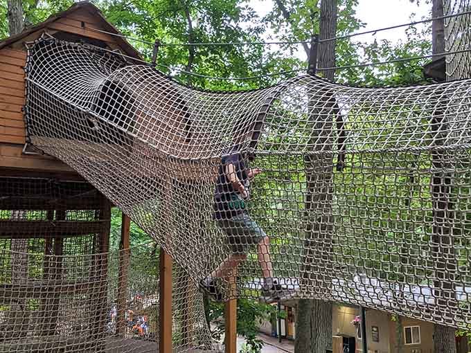 Scaling a giant cargo net between two wooden cabins. Your arms will remember this tomorrow, guaranteed.