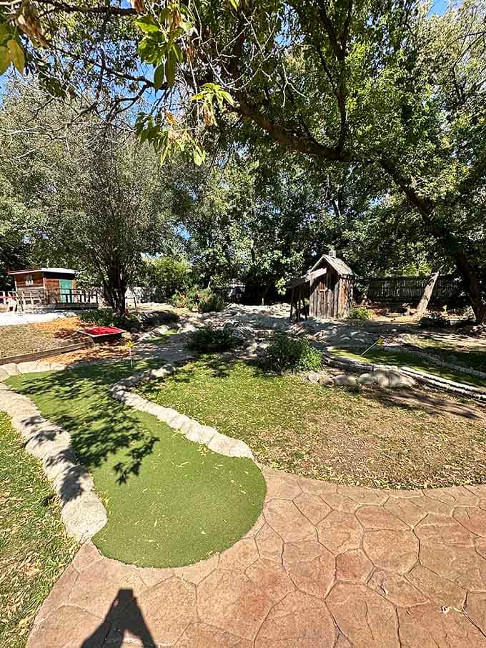 Tucked beneath mature trees, this charming mini golf course turns a burger stop into a full afternoon adventure.