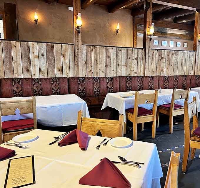 Warm sconce lighting, wood-paneled walls, and crimson napkins folded just so. Frontier dining with genuine elegance.