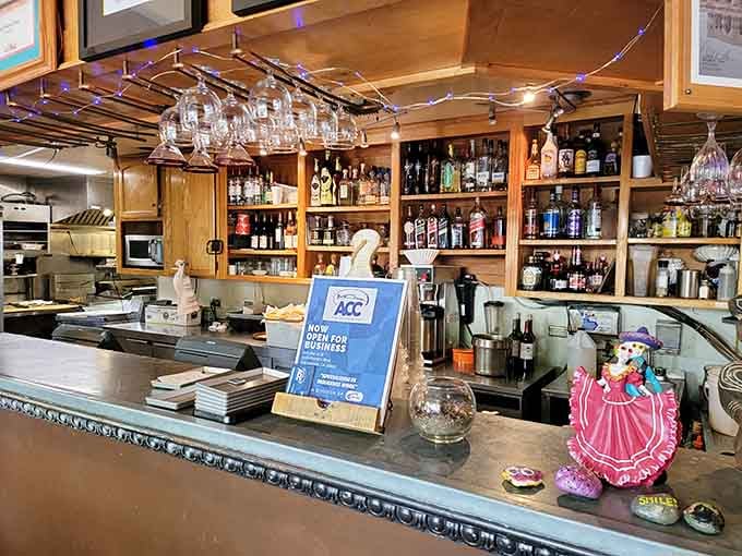 A full bar with wine glasses hanging overhead and bottles lined up like they're ready for anything you've got planned.