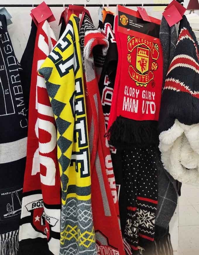 Soccer scarves, winter knits, and team gear hanging together like the world's most eclectic sports fan's closet.