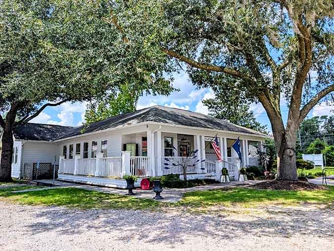 A welcoming white cottage shaded by a grand live oak, the kind of porch that makes you want to sit and stay awhile.