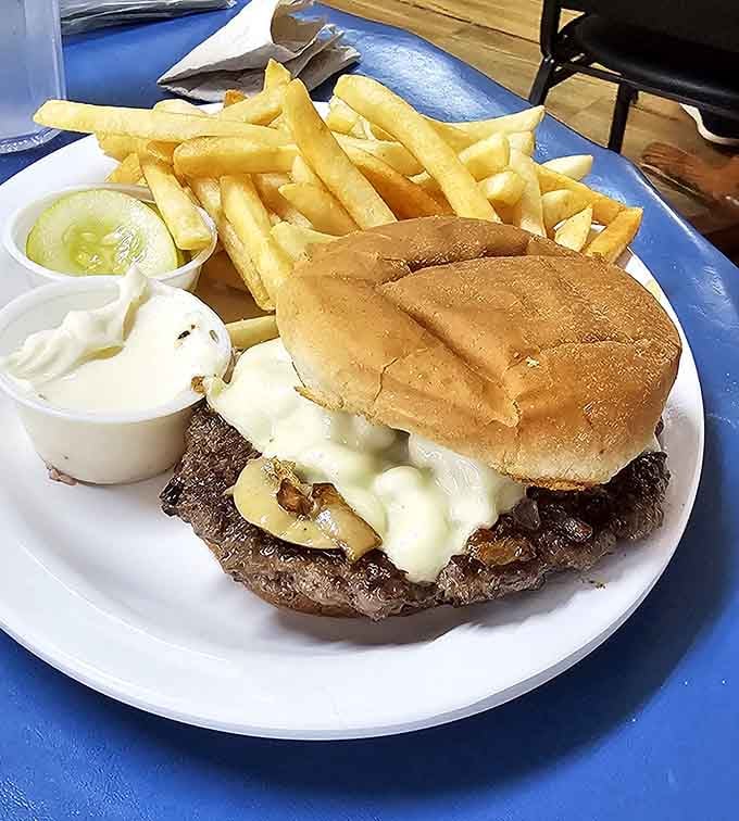 A Mushroom and Swiss burger with melted cheese cascading down the sides, fries alongside. Lunch just got very serious.