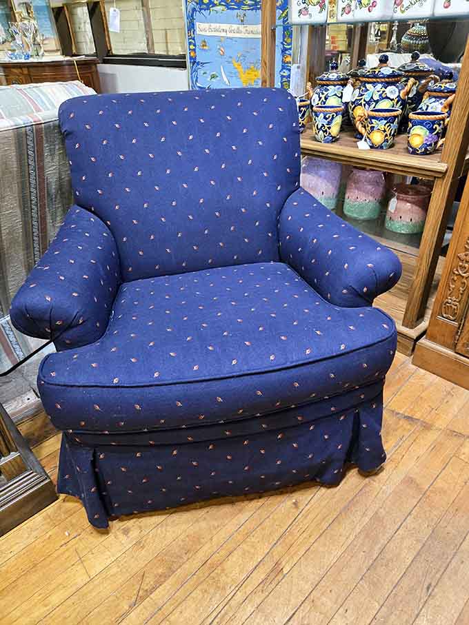 That deep blue armchair is basically asking you to sit down and stay a while.