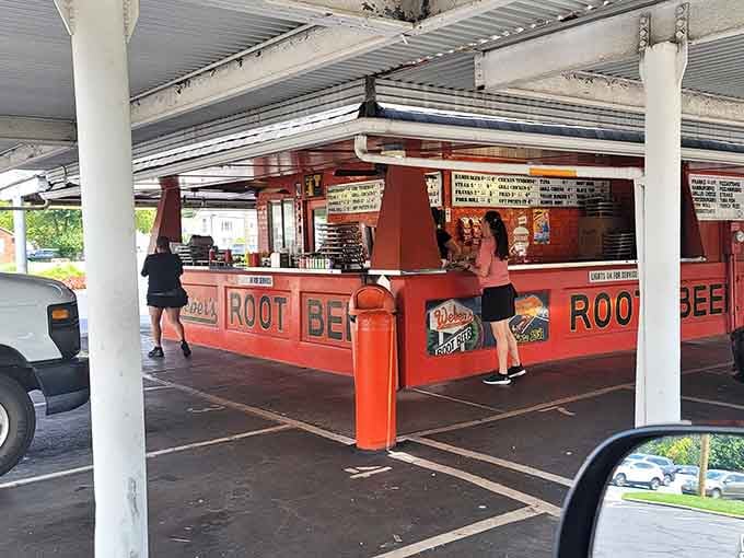 A customer at the counter, surrounded by bold red signage, soaking in the full Weber's experience firsthand.