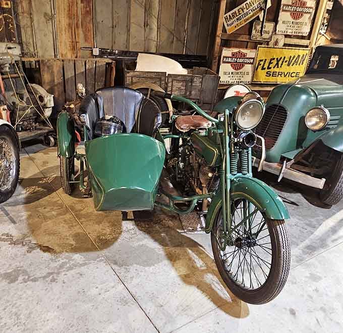 A green motorcycle with a matching sidecar, parked beneath vintage Harley-Davidson dealer signs, looks like it just rolled out of a 1920s adventure novel.