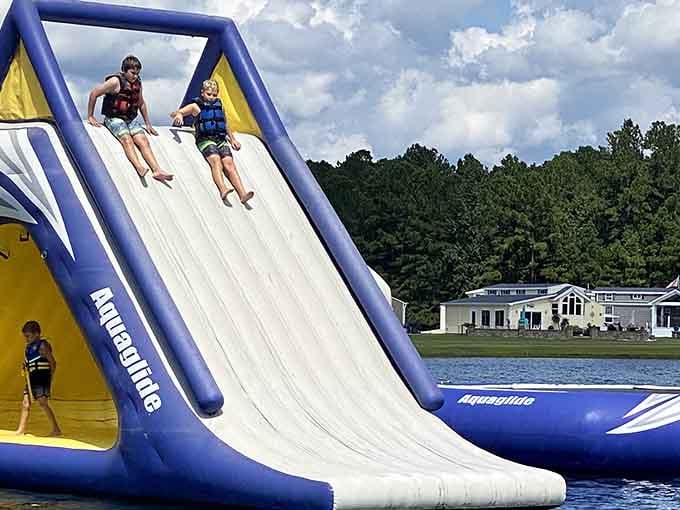 Two kids at the top of a giant inflatable slide, about to make a splash that nobody will forget anytime soon.
