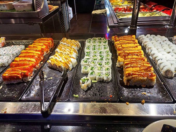 Row after row of fresh sushi rolls, drizzled and ready. This buffet sushi station is genuinely impressive.