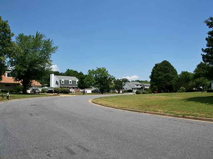 Take a relaxing stroll or bike ride down this quiet, curving neighborhood street lined with large, shady green trees.