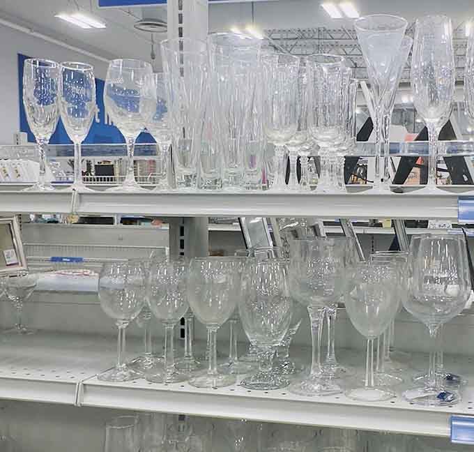 Rows of sparkling crystal and glass stemware catching the light, elegant champagne flutes and wine glasses that look like they belong at a dinner party.