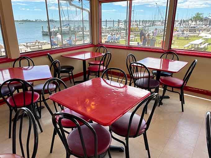 Red tables, big windows, and sailboats bobbing just outside, this is the kind of view that makes every bite taste even better.