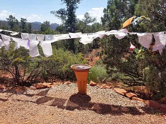 A simple water basin surrounded by prayer flags becomes something contemplative in this serene desert setting.