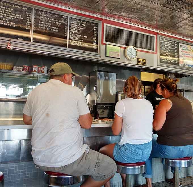 Three people at the counter, shoulders relaxed, coffee in hand, this is what a good diner does to a person.