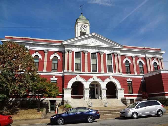The Calhoun County Courthouse clock tower stands proud against brilliant blue sky, radiating timeless civic dignity beautifully.