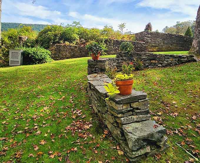 Terracotta pots perched on dry-stacked stone walls, a small and cheerful detail that reminds you someone here really loves this place.
