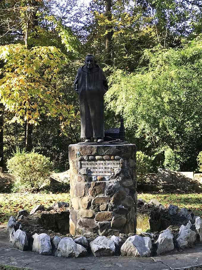 A bronze tribute to the monk who built a world, standing tall among the trees he loved.