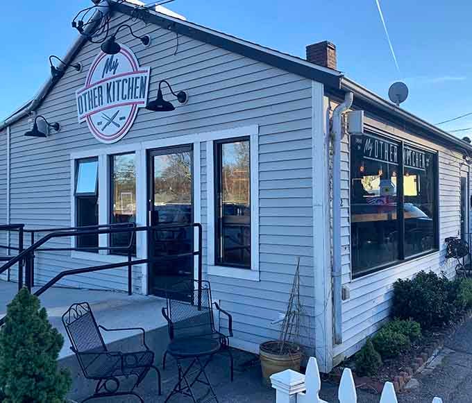 Cozy gray cottage restaurant with black outdoor seating that whispers "stay awhile" louder than any welcome sign could.
