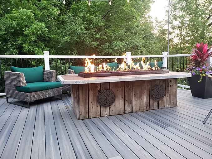 The outdoor fire table creates the perfect gathering spot for evening conversations under the trees.