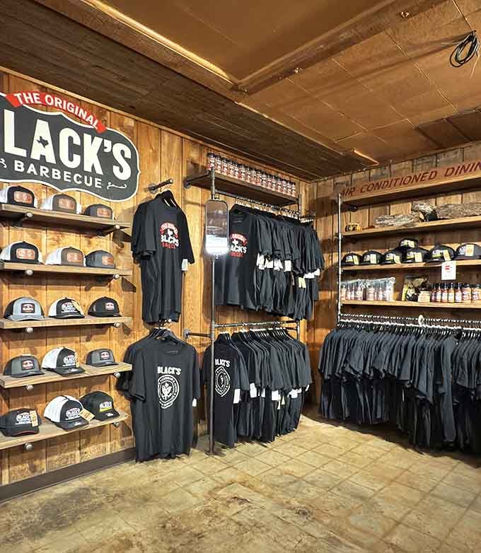 Black's branded hats and tees lined up neatly, because apparently great barbecue inspires the kind of loyalty that requires a souvenir.