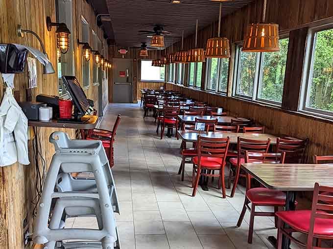 A bright, windowed dining room lined with red chairs and warm pendant lights. Lunch here feels like a mini vacation.