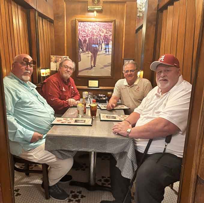 Four friends, a checkered tablecloth, and a framed photo of Alabama football watching over them, this booth has seen some stories.