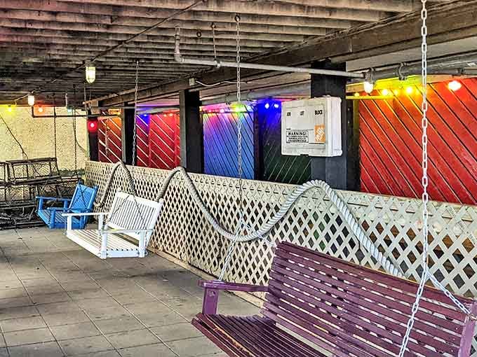 Porch swings and colorful string lights underneath the building. Waiting for a table here is genuinely enjoyable.