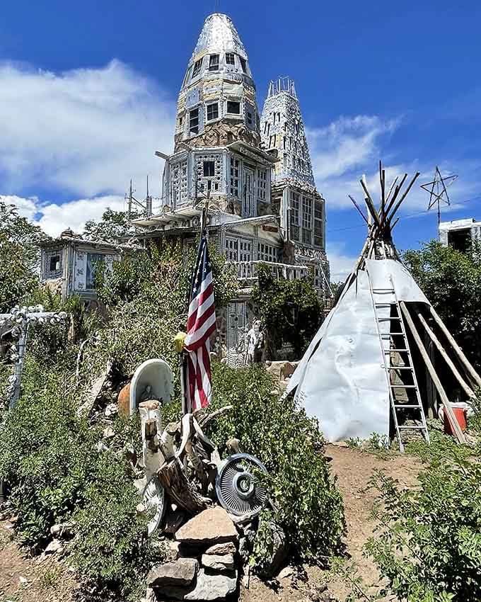 An American flag, a tipi, and two soaring towers share the yard, telling a layered story about identity, pride, and creativity.