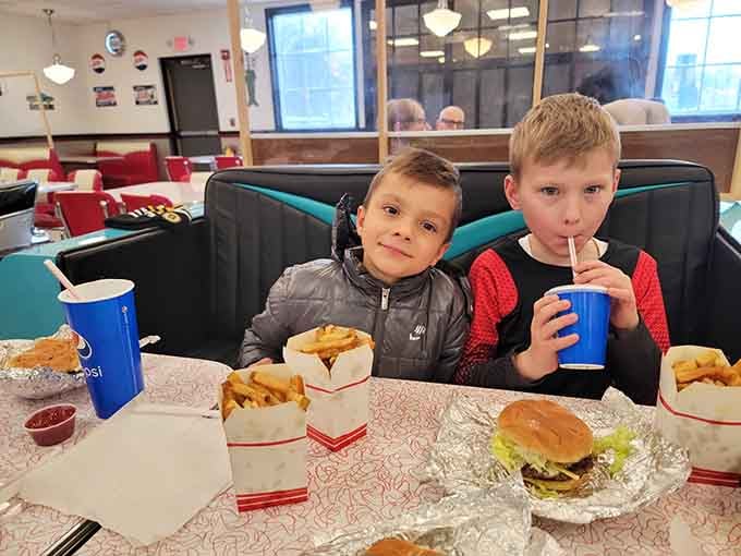 Two kids, a pile of fries, and the kind of happiness that no screen can replicate. Pure gold.