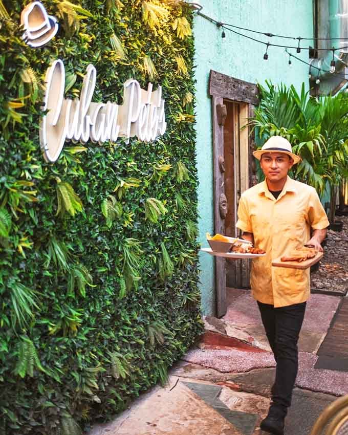 Service with a smile and a panama hat because presentation matters even when you're carrying empanadas.