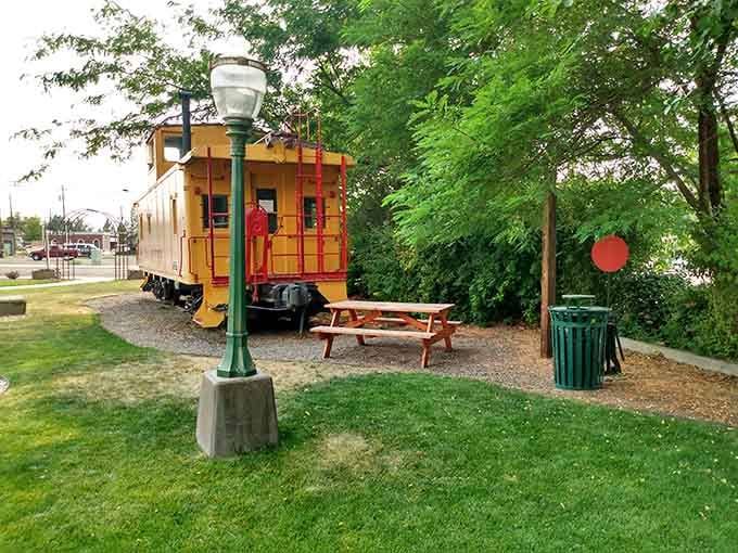 A bright yellow caboose parked in a shady corner of town, because Dayton keeps its history close and colorful.