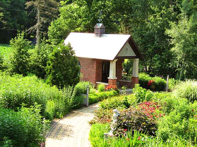A brick pavilion surrounded by lush greenery. This garden keeps producing architectural surprises around every corner.
