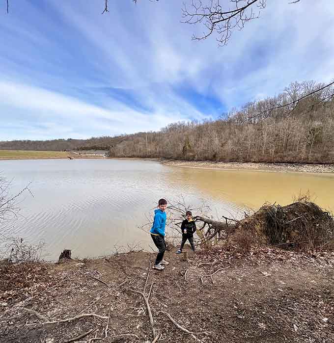 Two kids, a fallen tree, and a muddy winter shoreline. This is what adventure actually looks like at any age.