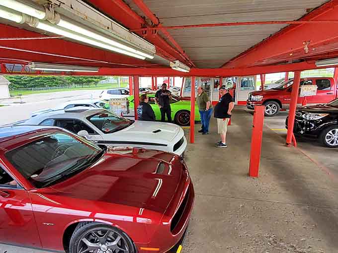 Under the red beams at Dog n Suds, even the parking area feels like part of the whole experience.