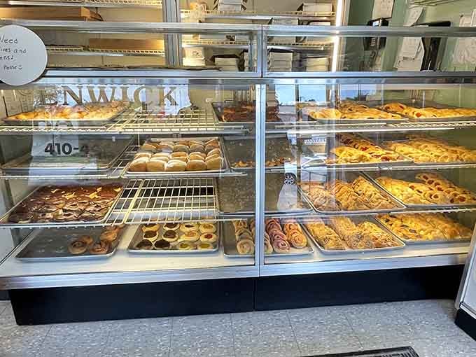 Two display cases packed with pastries, Danish, and donuts. Choosing just one thing is technically possible but deeply unrealistic.