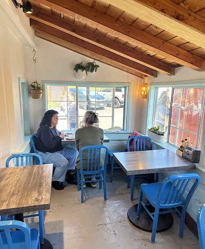 Locals and visitors sharing tables under wooden beams and warm light. Good food has a way of bringing everyone together.