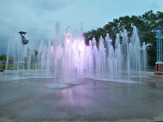 The splash pad at night glows purple and pink, turning an ordinary evening into something your grandkids will talk about forever.
