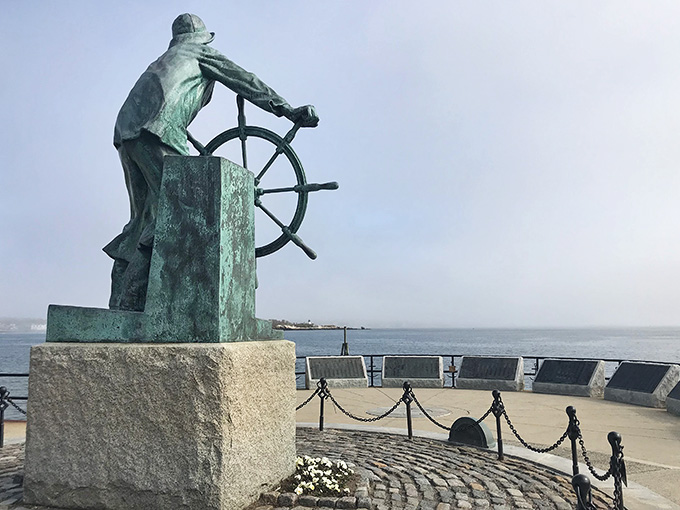 From behind, the fisherman faces the open harbor directly. He always has. He always will.